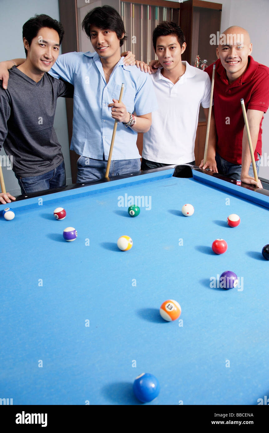 Men standing around pool table Stock Photo - Alamy