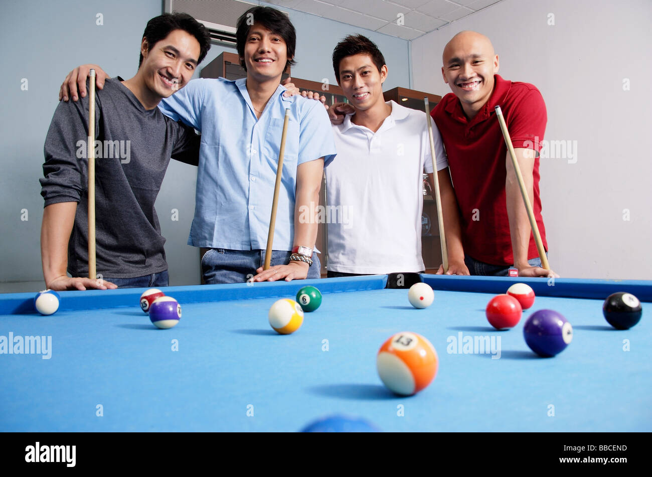 Men standing around pool table, looking at camera Stock Photo - Alamy
