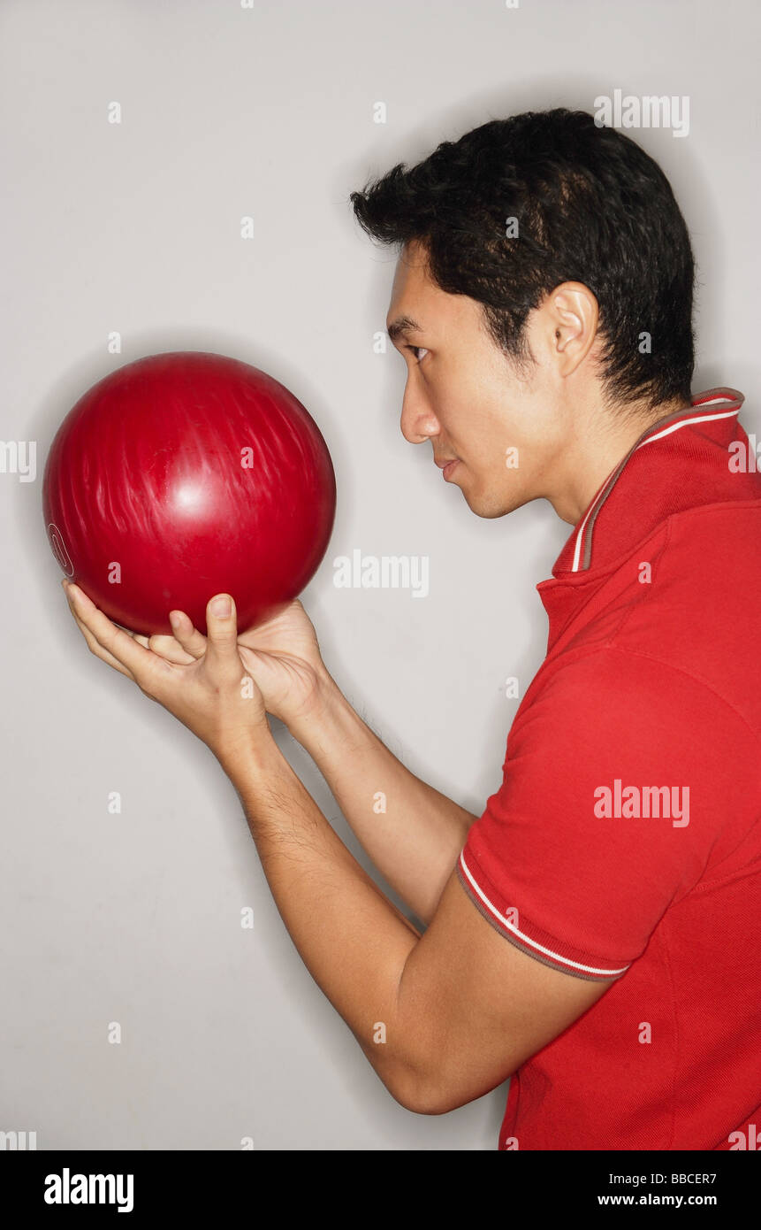 Man holding bowling ball in front of face Stock Photo - Alamy