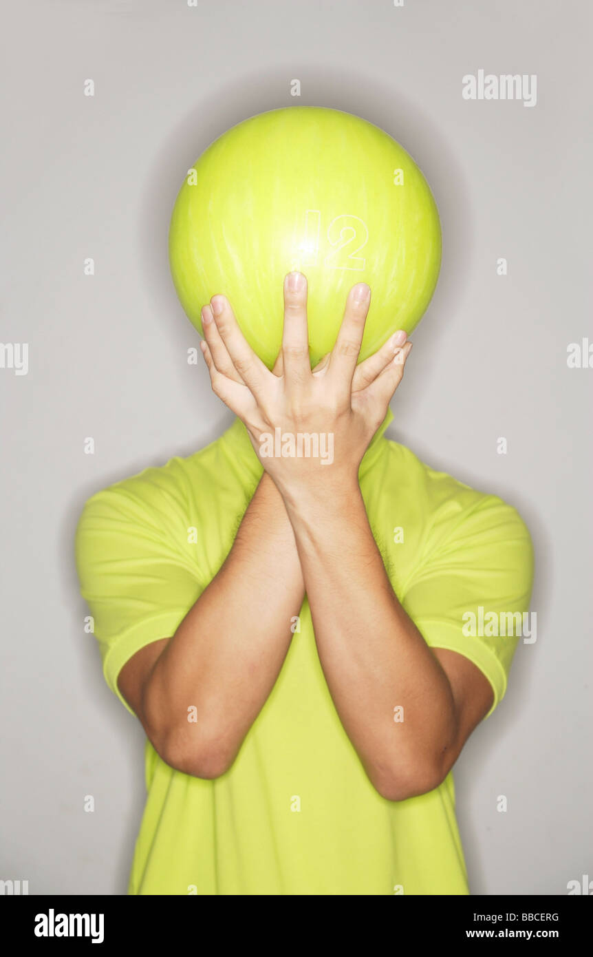 Man holding bowling ball in front of his face Stock Photo - Alamy