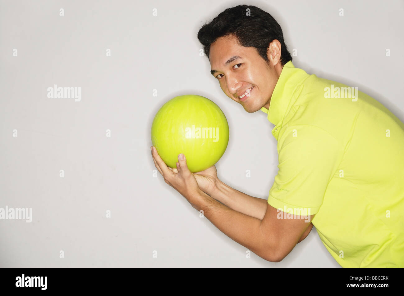 Man holding bowling ball, turning to smile at camera Stock Photo - Alamy