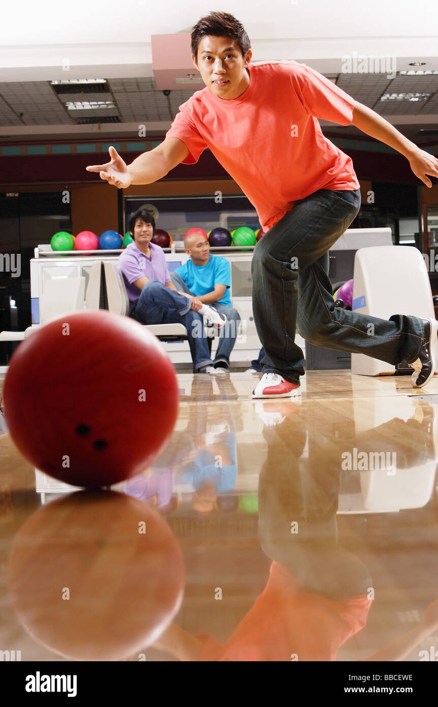Man bowling, people sitting in the background Stock Photo - Alamy