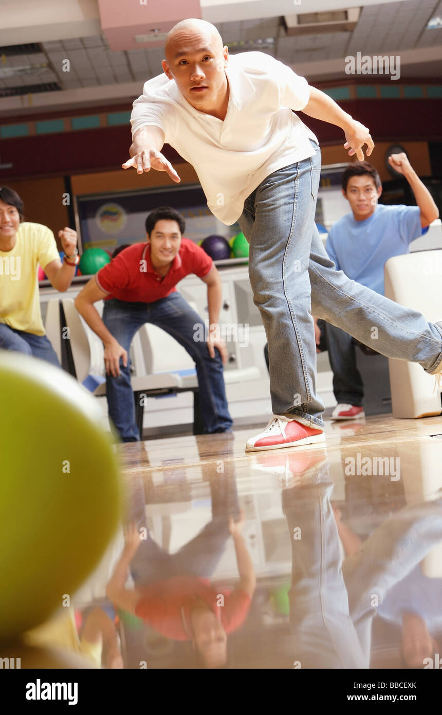 Man bowling, friends in the background, cheering Stock Photo - Alamy
