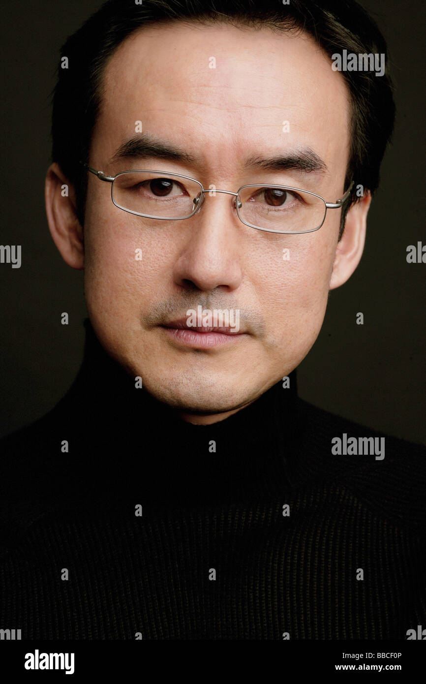 Man looking at camera, head shot, black background Stock Photo - Alamy