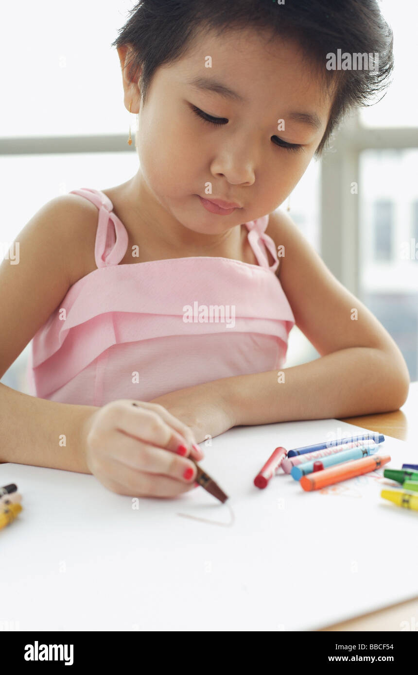 Young girl with crayons, looking down Stock Photo - Alamy