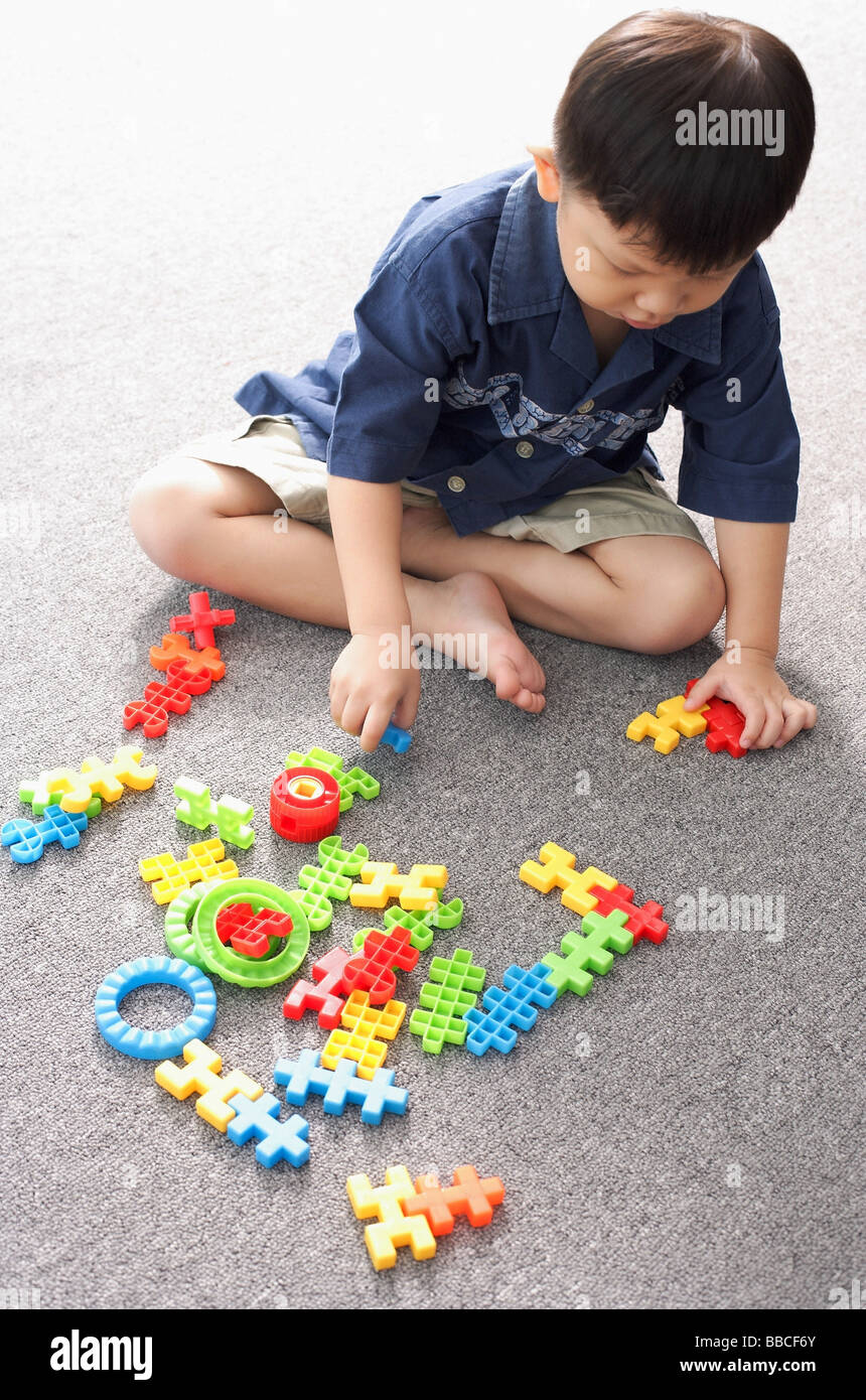 Young boy playing with building block toys Stock Photo - Alamy
