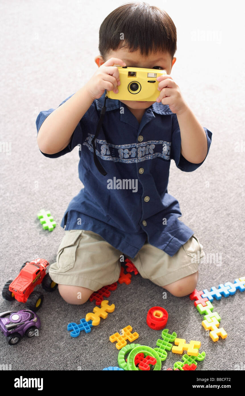 Young boy playing with toy camera, holding in front of his face Stock ...