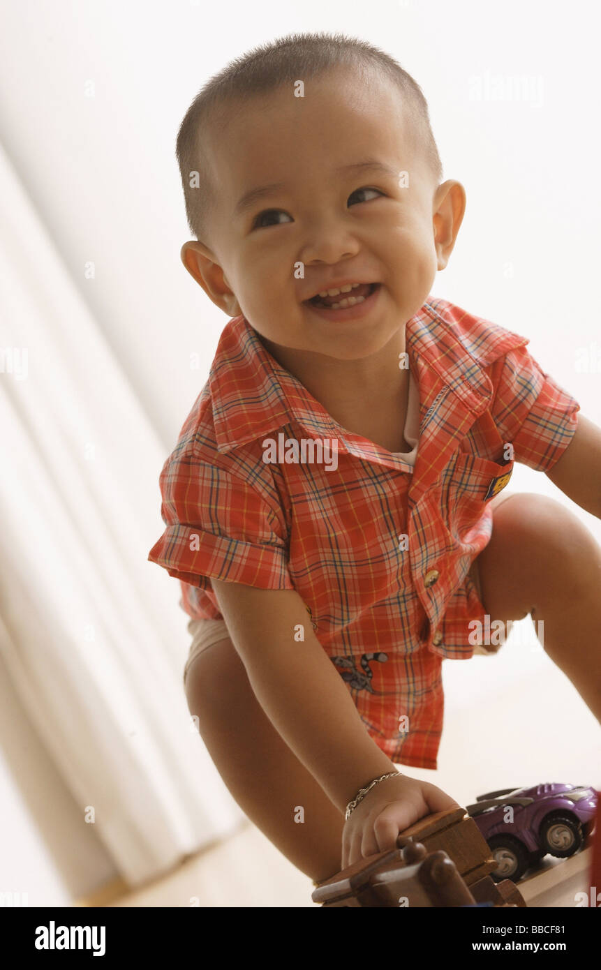 Young boy trying to stand, smiling Stock Photo - Alamy