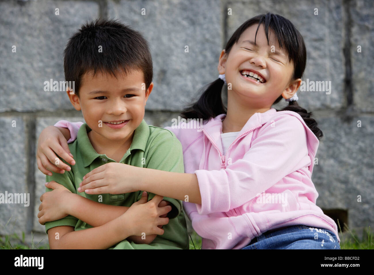 Girl with arms around boy Stock Photo - Alamy