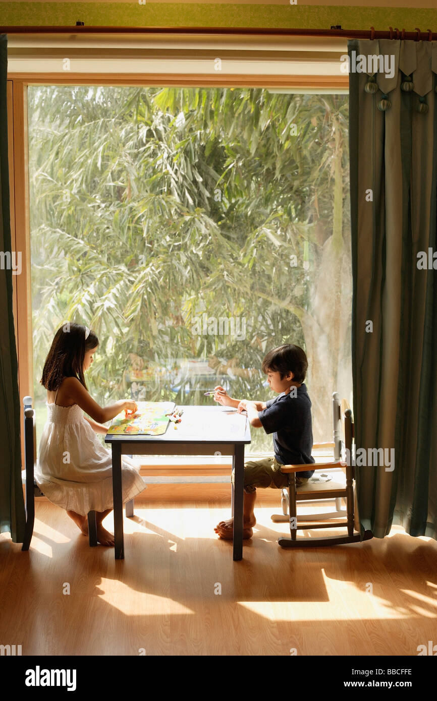 two children playing at table Stock Photo - Alamy