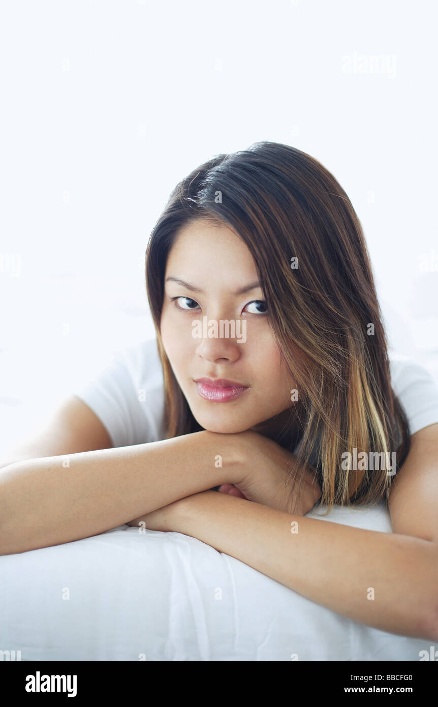 Woman looking at camera, lying on front, arms crossed Stock Photo - Alamy