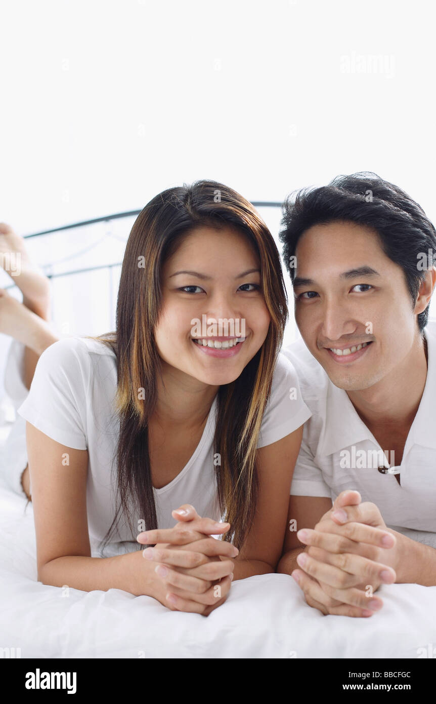 Couple on bed, smiling at camera Stock Photo - Alamy