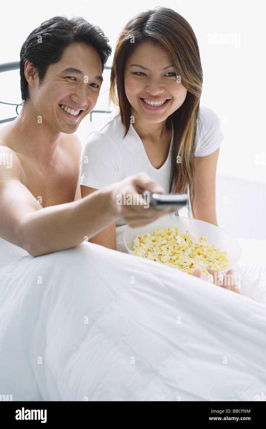 Asian watching tv on bed hi-res stock photography and images - Alamy