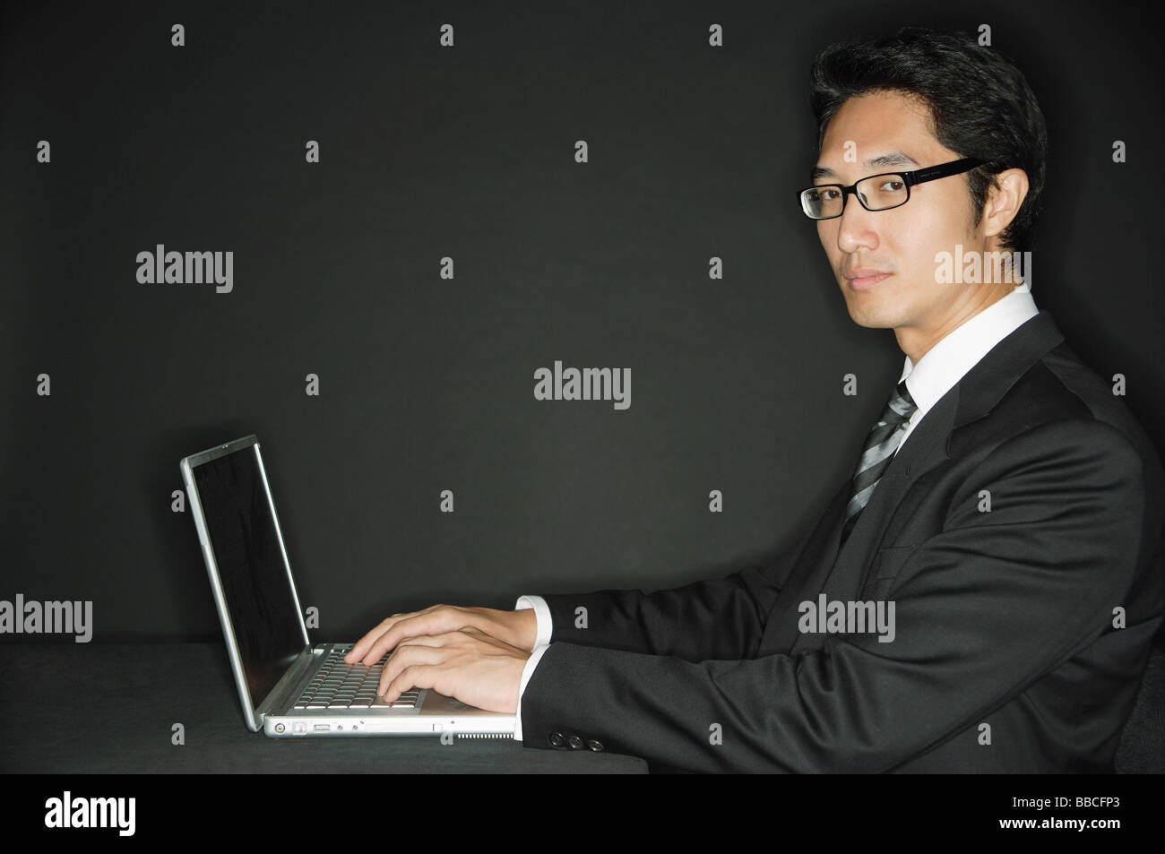 Businessman wearing glasses, with laptop, portrait Stock Photo - Alamy