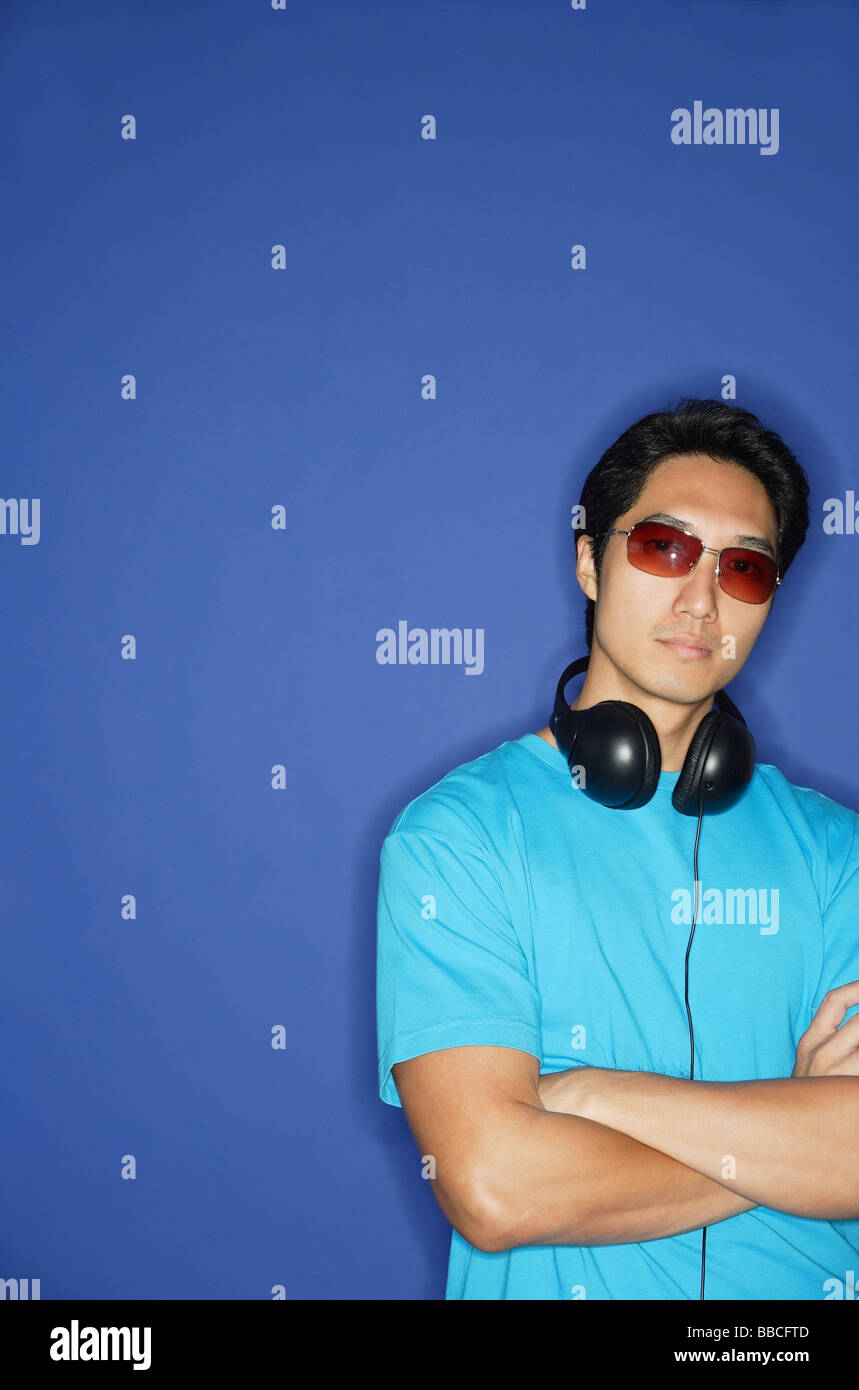 Man with sunglasses, headphones around his neck, arms crossed Stock ...