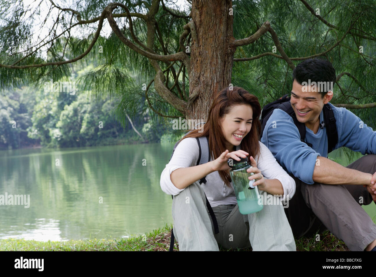 couple resting under tree Stock Photo - Alamy