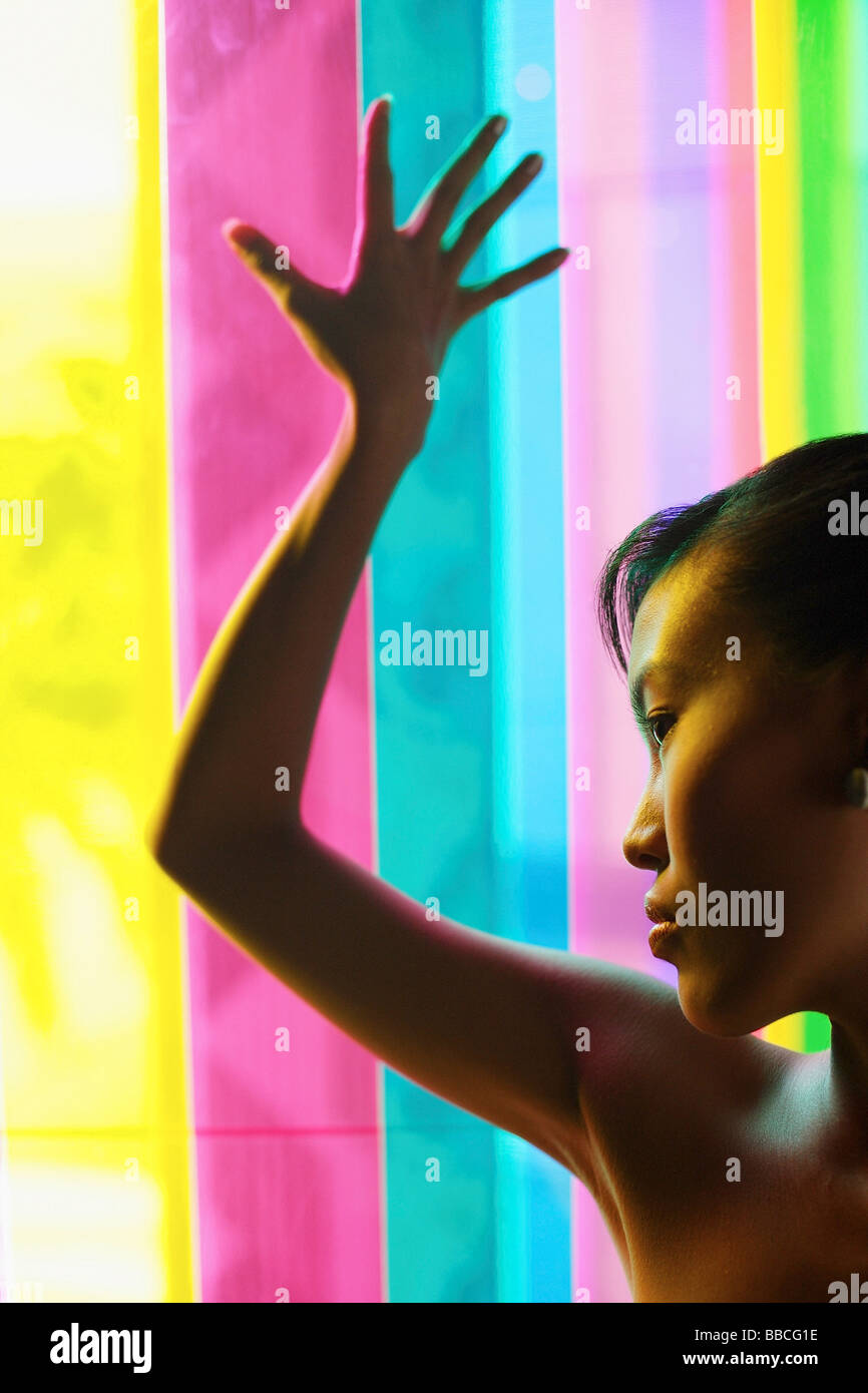 Woman leaning hand against coloured glass Stock Photo - Alamy