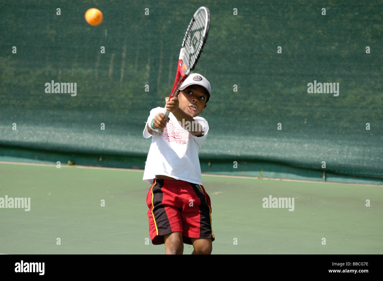 A young boy playing tennis making a backhand return Stock Photo - Alamy