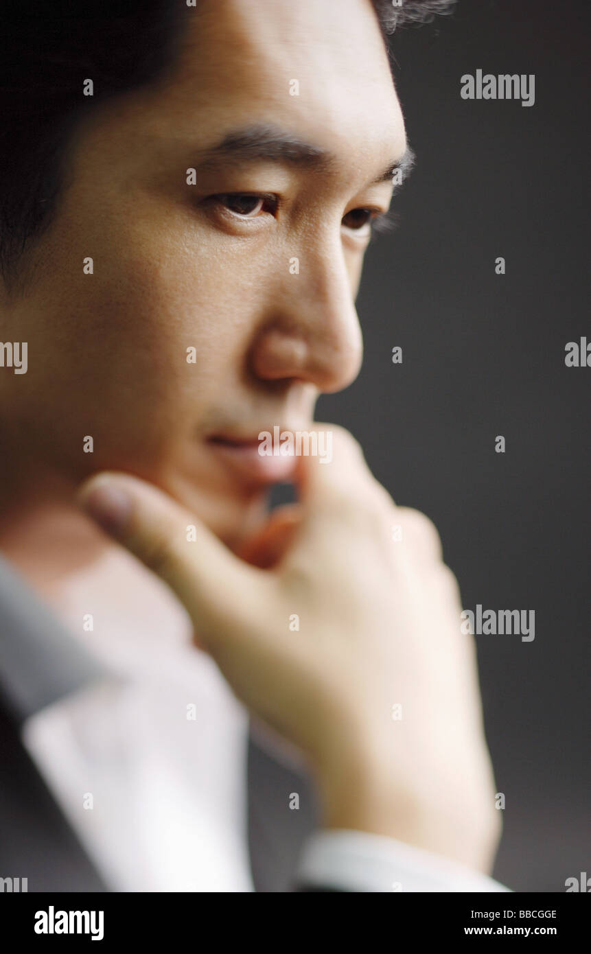 Man with hand on chin, head shot Stock Photo - Alamy