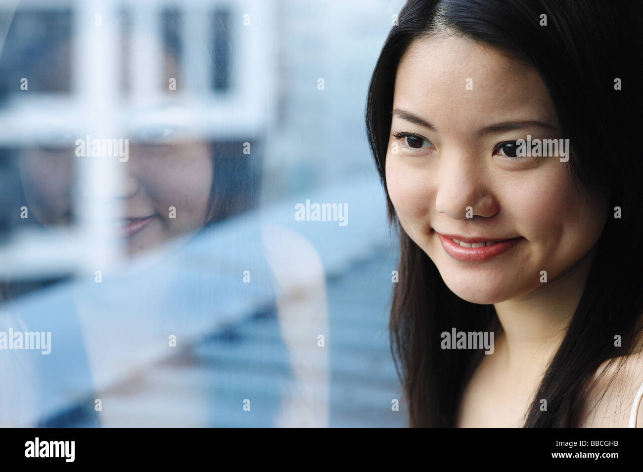 Young woman looking through window, portrait Stock Photo - Alamy
