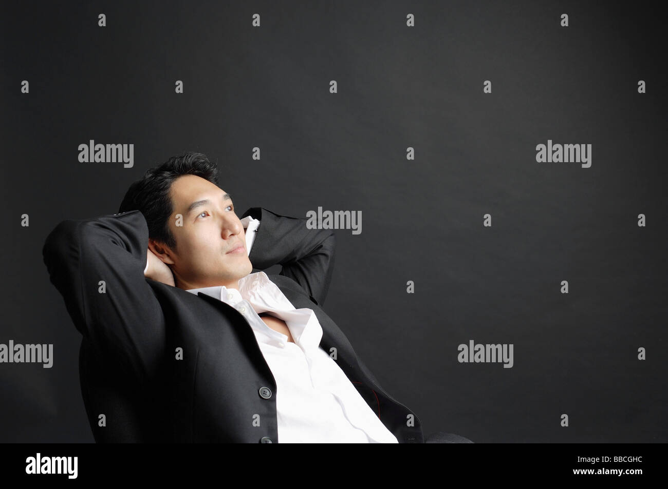 Man leaning back, hands behind head Stock Photo - Alamy