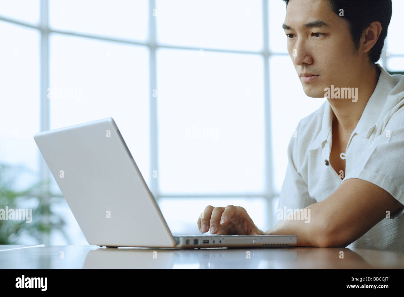 Man sitting, using laptop Stock Photo - Alamy