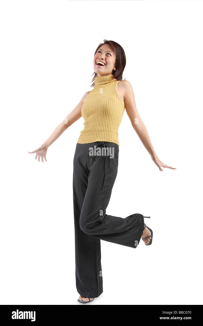 Young woman standing with one leg up, looking away Stock Photo - Alamy