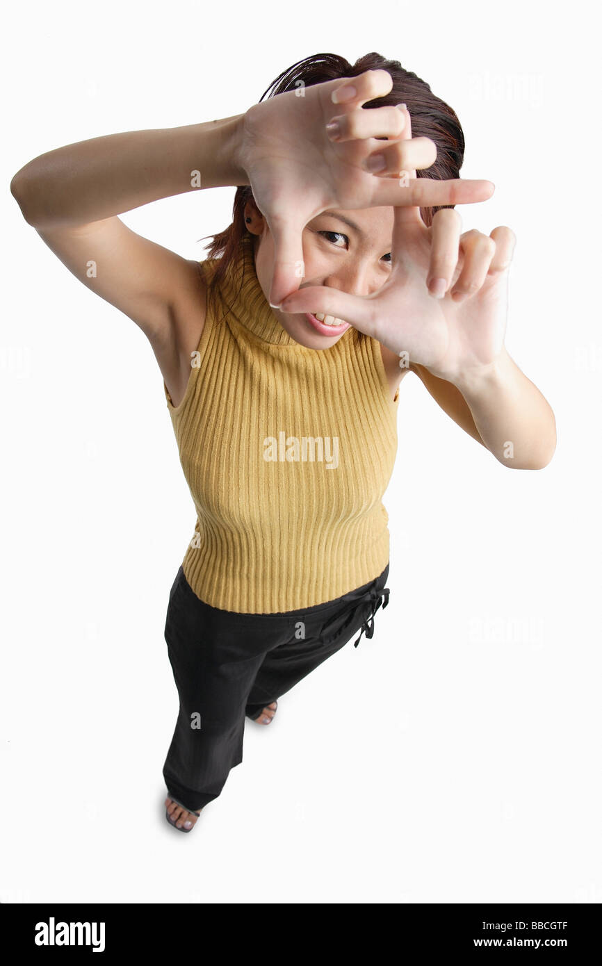 Young woman looking up at camera, through her hands Stock Photo - Alamy