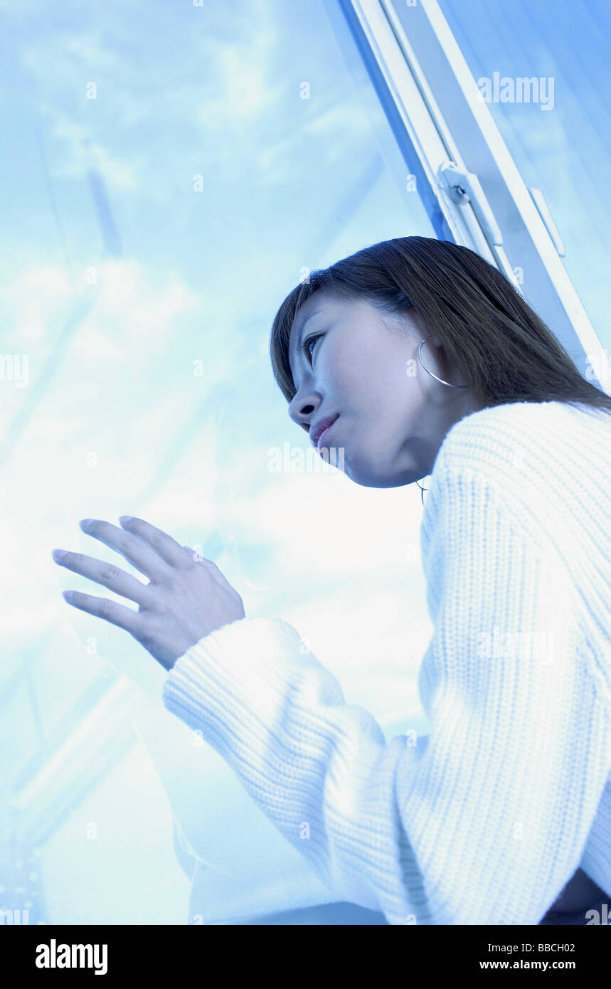 Woman leaning head on window, looking out Stock Photo - Alamy