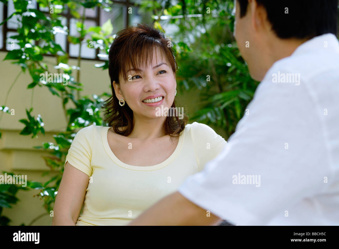 Woman facing man, smiling Stock Photo - Alamy