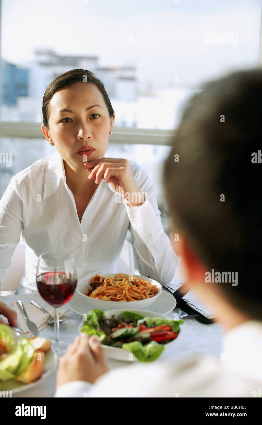 Businesswoman with hand on chin, facing another person Stock Photo - Alamy