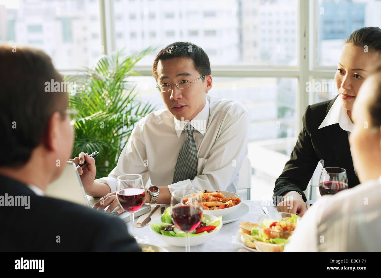 Businessmen and women, talking over lunch Stock Photo - Alamy