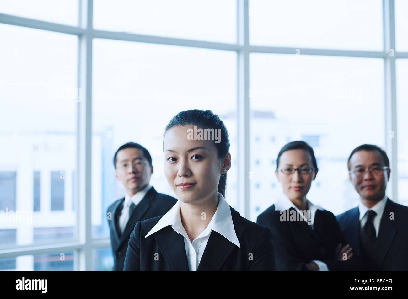 Executives standing in a row, looking at camera Stock Photo - Alamy