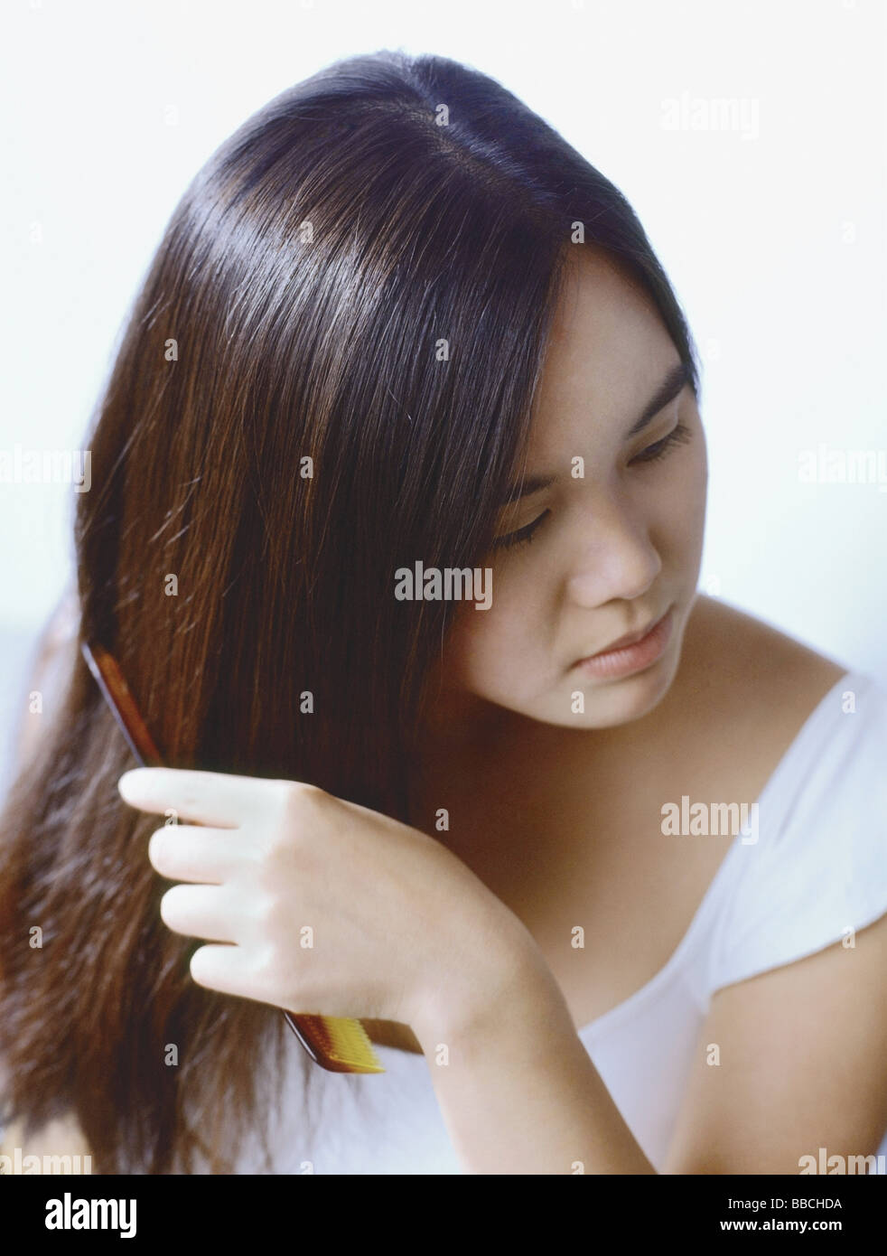 Teenage girl combing hair Stock Photo - Alamy