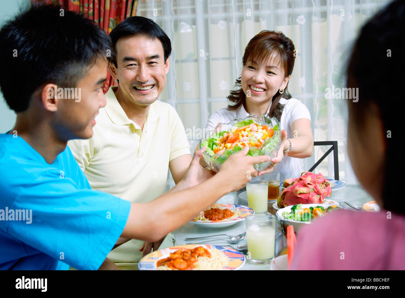 Mother passing food to family members Stock Photo - Alamy