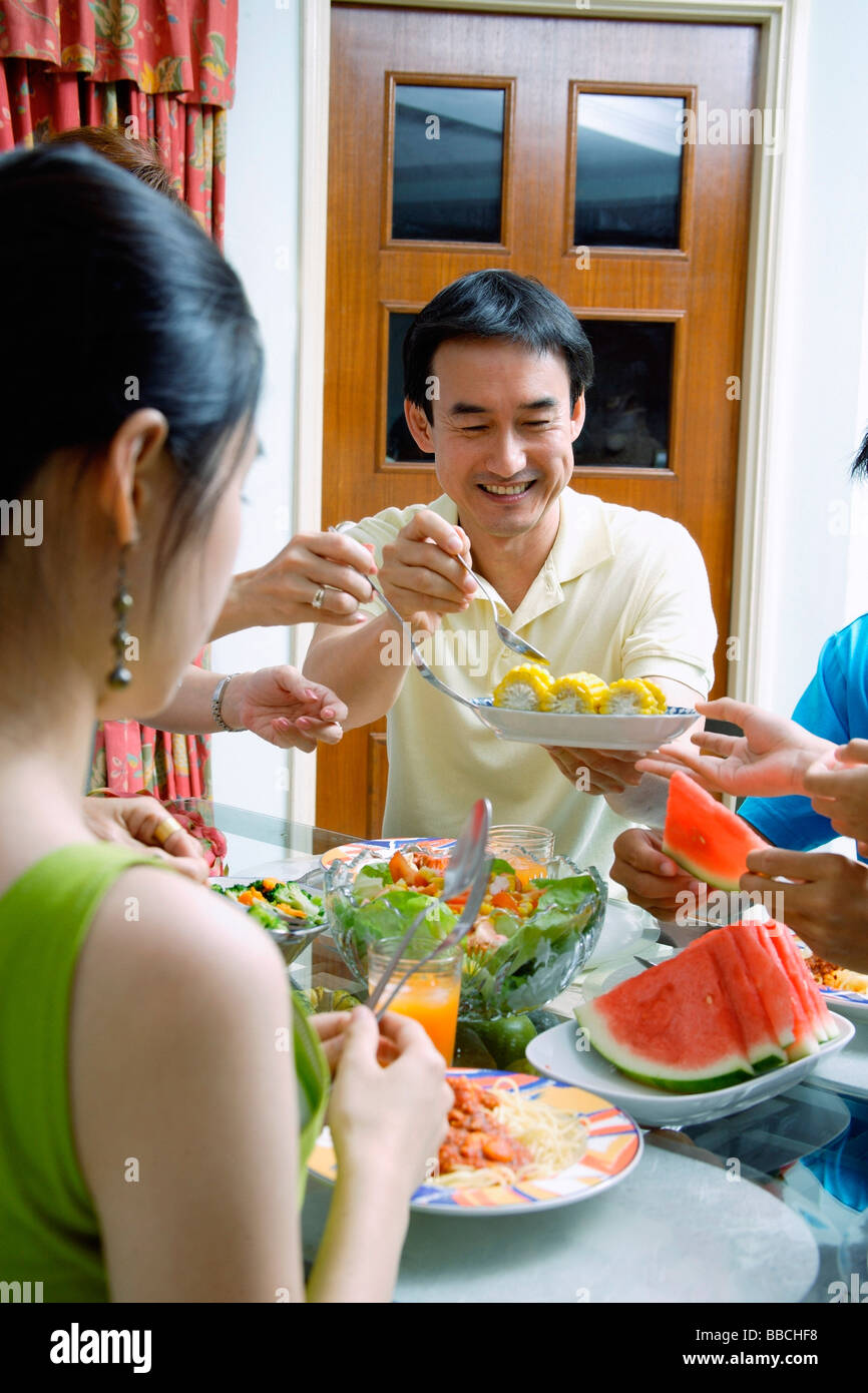 Father passing food to family members Stock Photo - Alamy