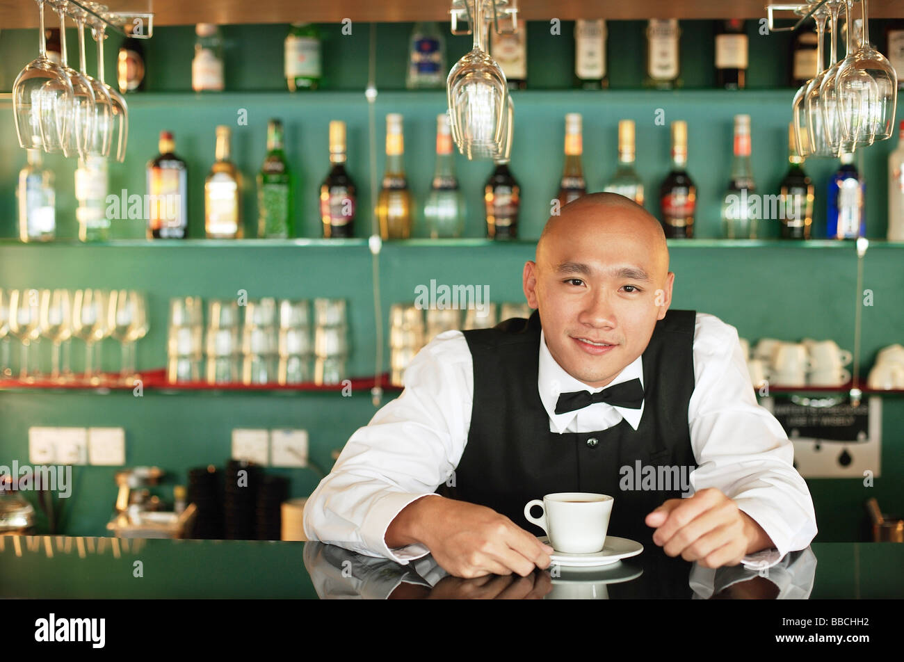 Bartender behind bar counter, with cup and saucer Stock Photo - Alamy