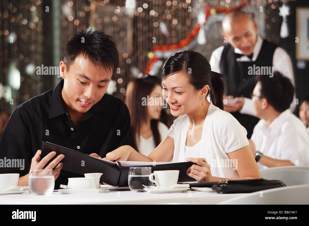 Couple in restaurant, looking through menu Stock Photo - Alamy