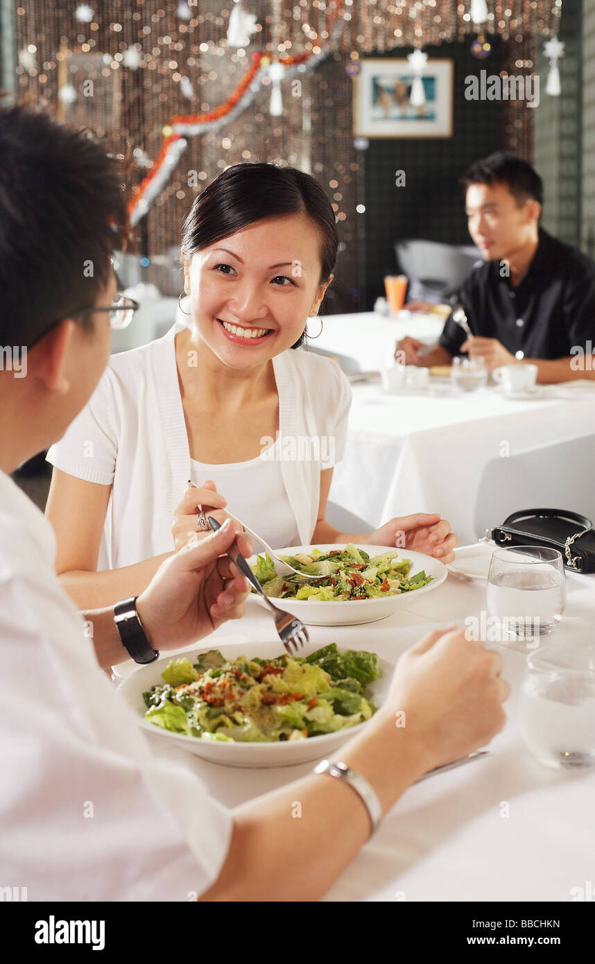 Couple eating at restaurant, people in the background Stock Photo - Alamy