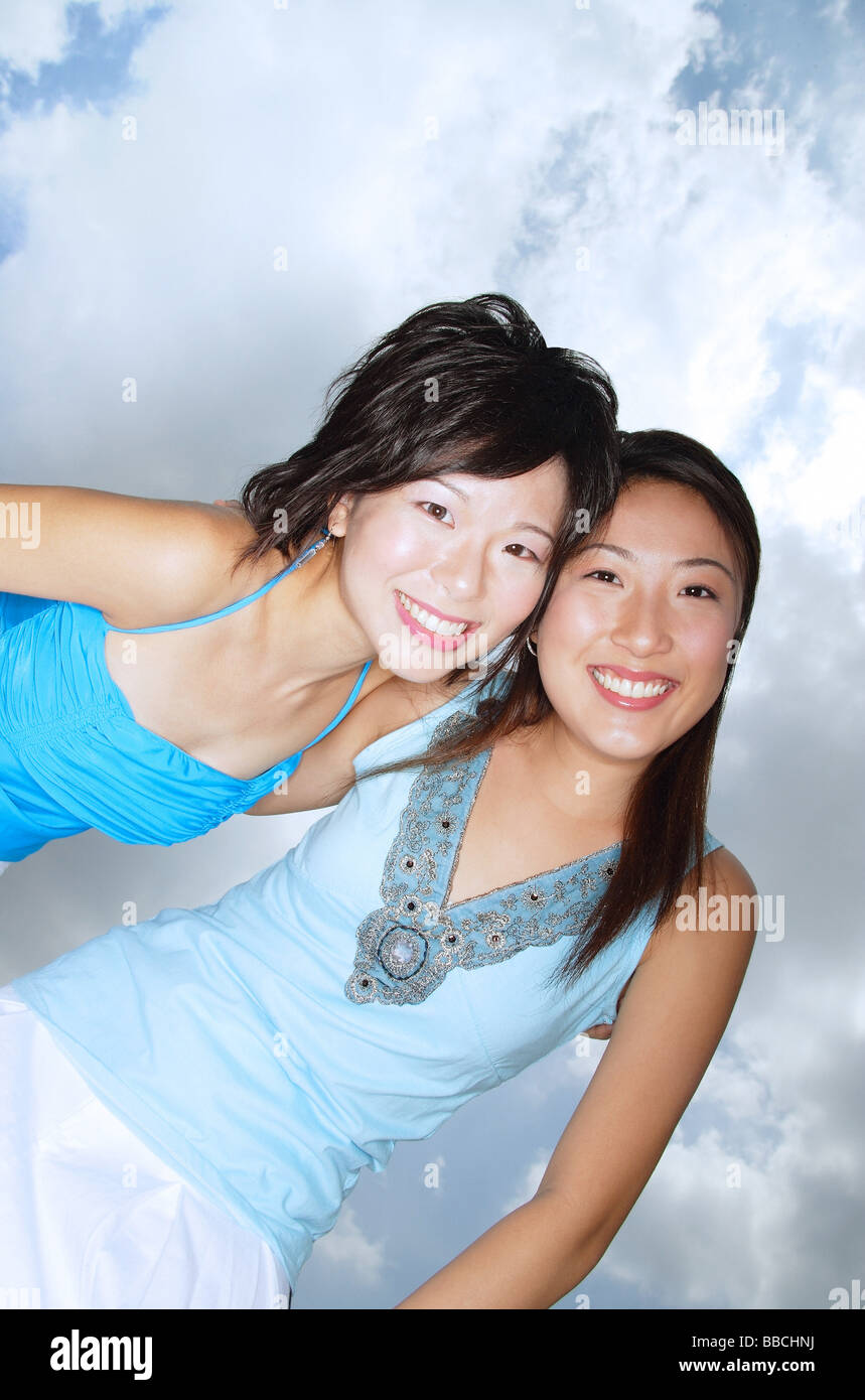 Two women smiling at camera, low angle view Stock Photo - Alamy