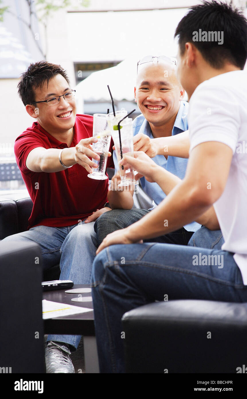 Three guys toasting with drinks Stock Photo - Alamy