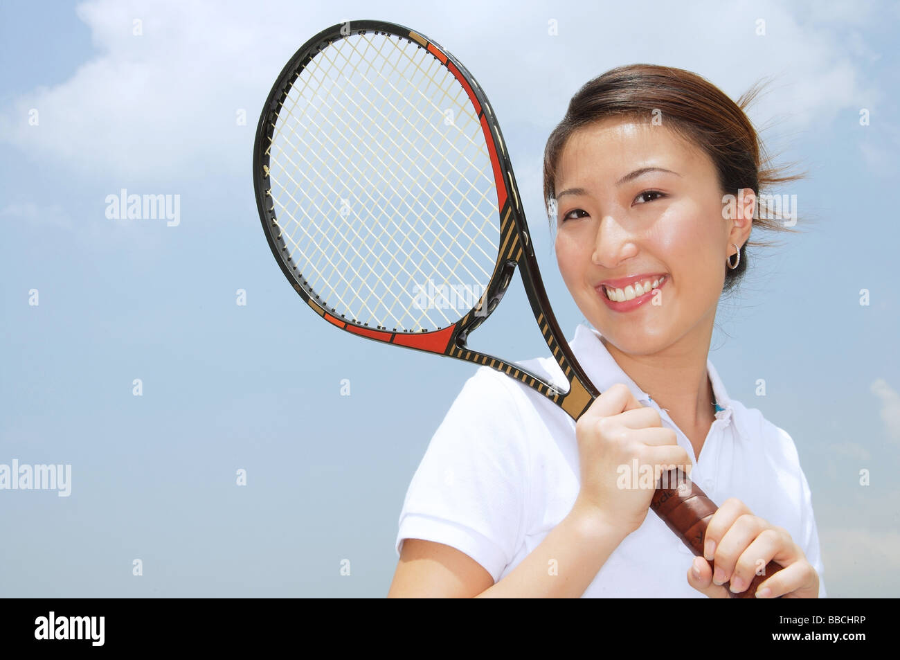 Young woman holding tennis racket, smiling at camera Stock Photo - Alamy