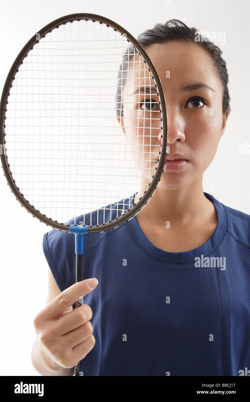 Woman holding badminton racket next to her face hi-res stock ...