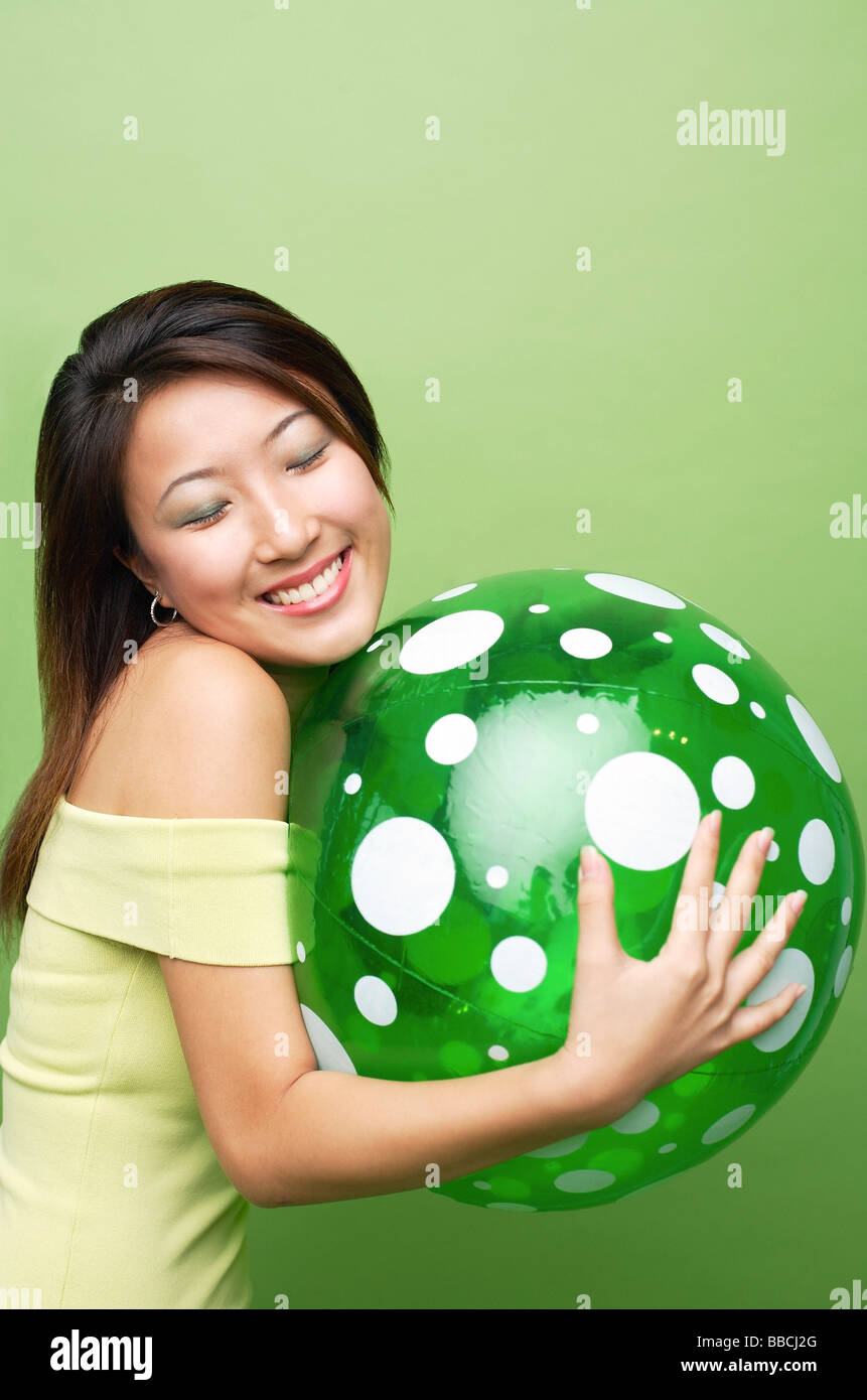 Woman hugging inflatable ball, eyes closed Stock Photo - Alamy