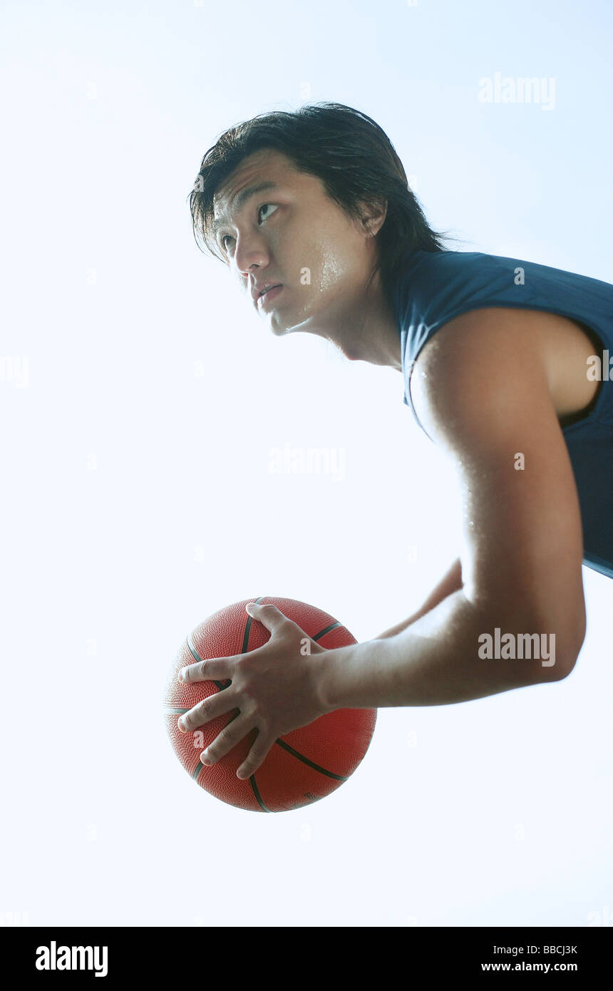 Man holding basketball, looking up Stock Photo - Alamy