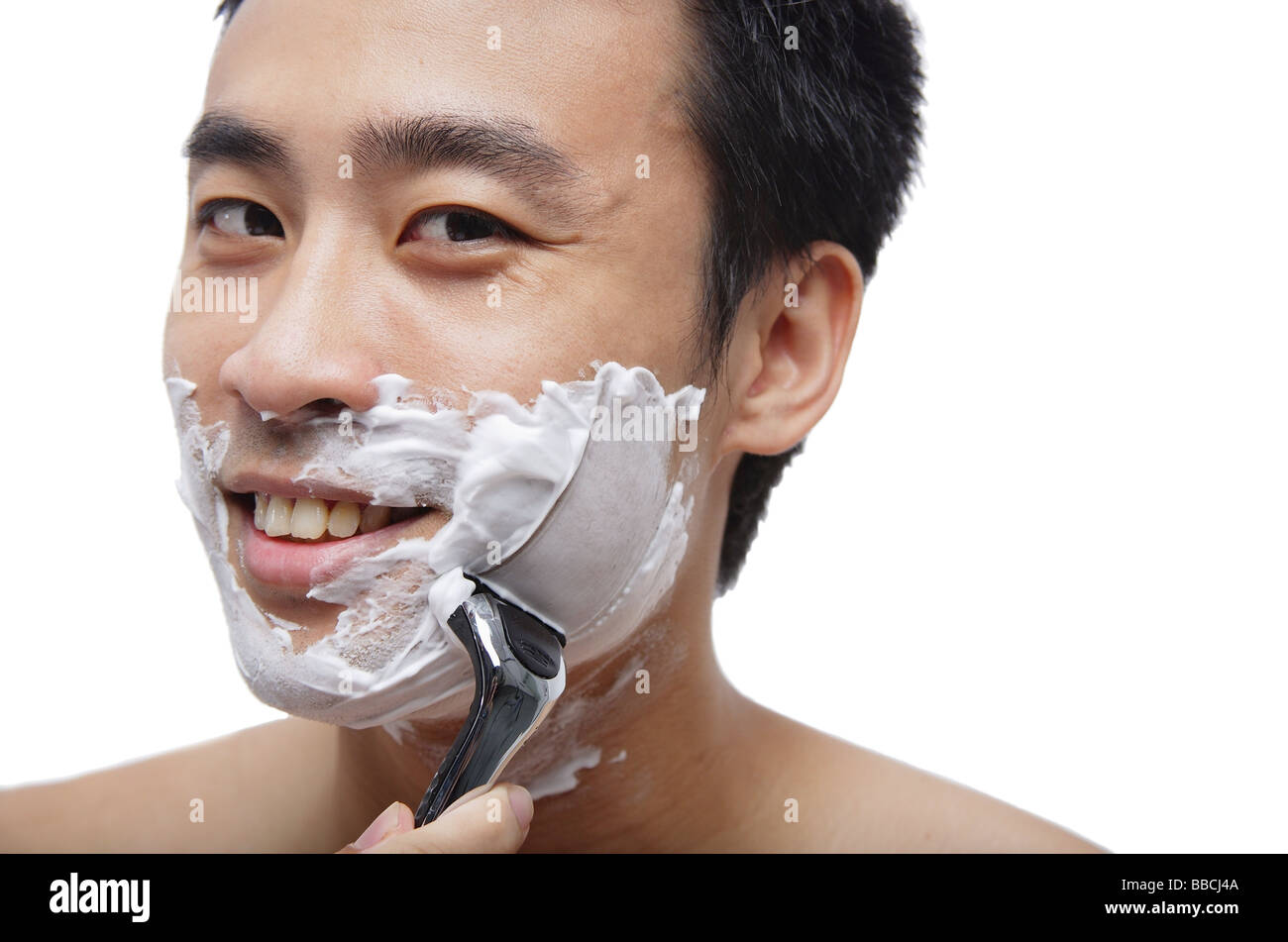 Man shaving face, looking at camera, smiling Stock Photo - Alamy