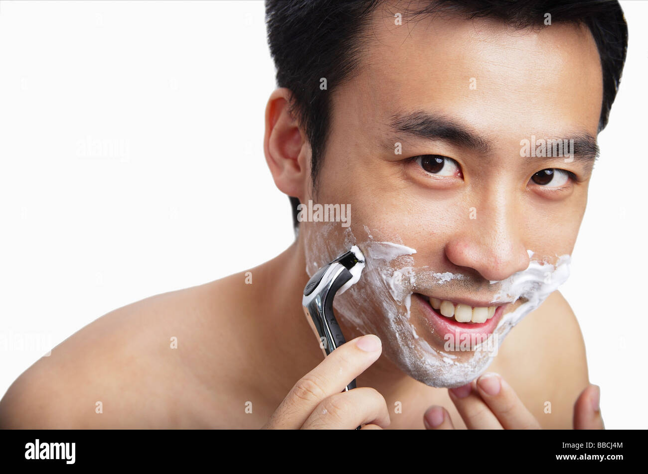 Man shaving, smiling at camera Stock Photo - Alamy