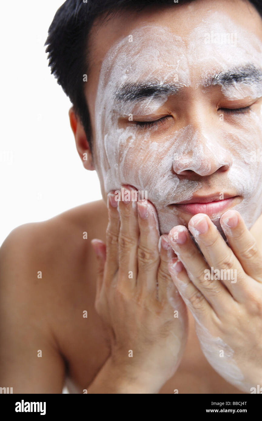 Man rubbing foam on face Stock Photo - Alamy