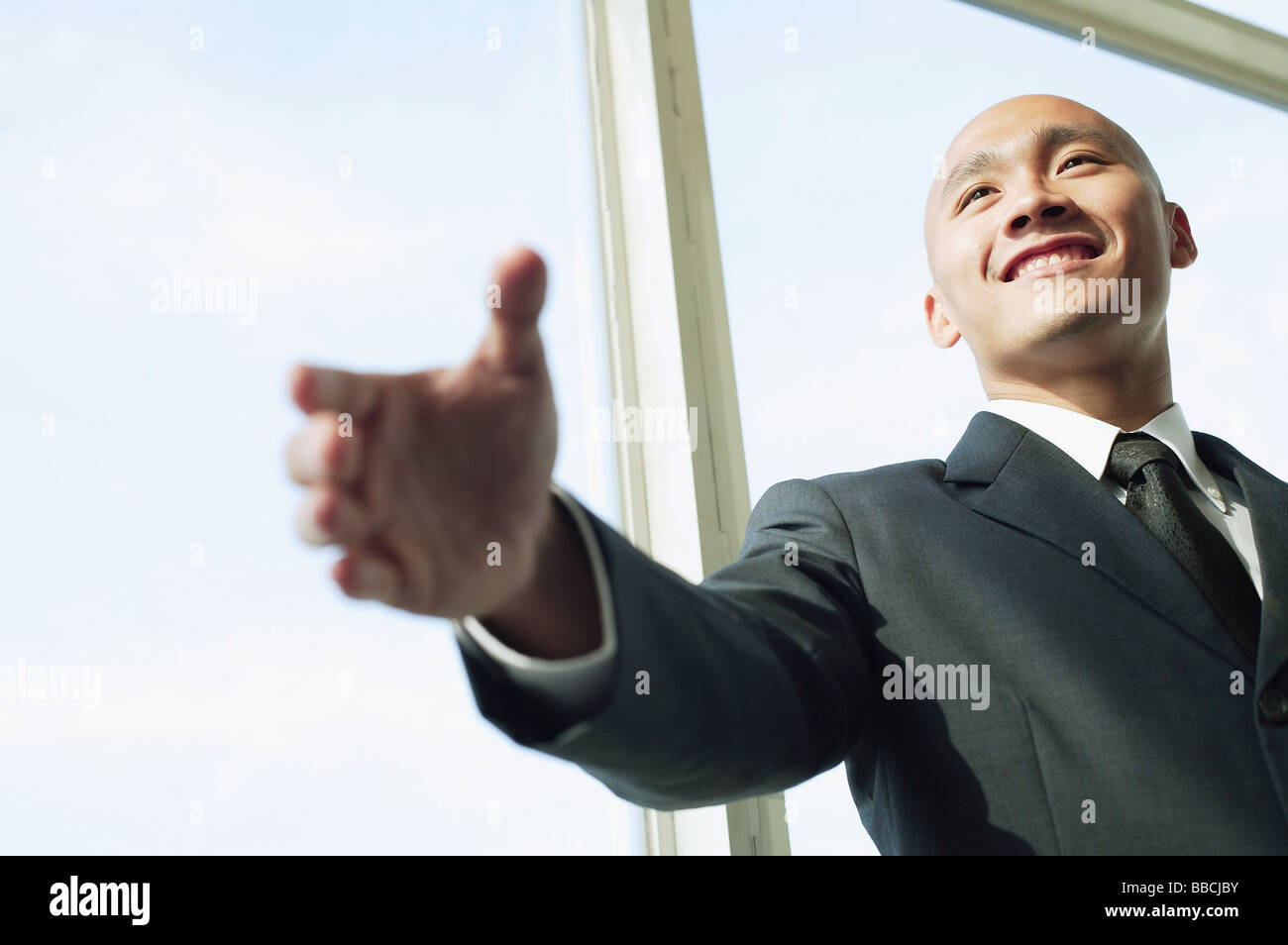 Businessman, hand outstretched, smiling Stock Photo - Alamy