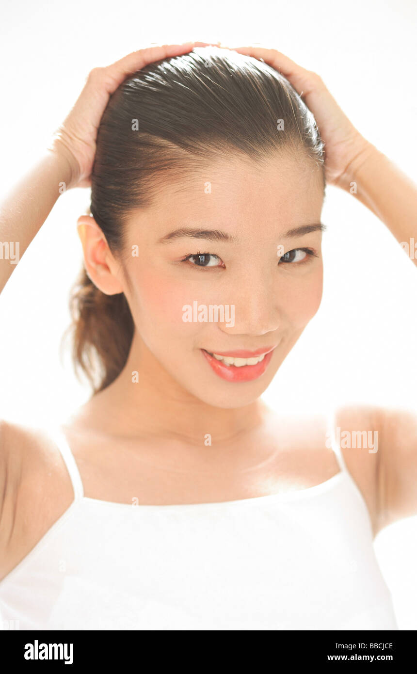 Woman looking at camera, both hands on head Stock Photo - Alamy